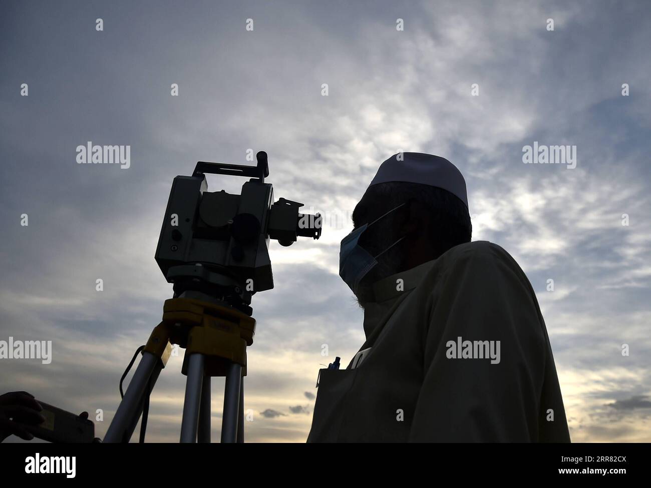210413 -- PESHAWAR, April 13, 2021 -- A man observes the crescent moon ...