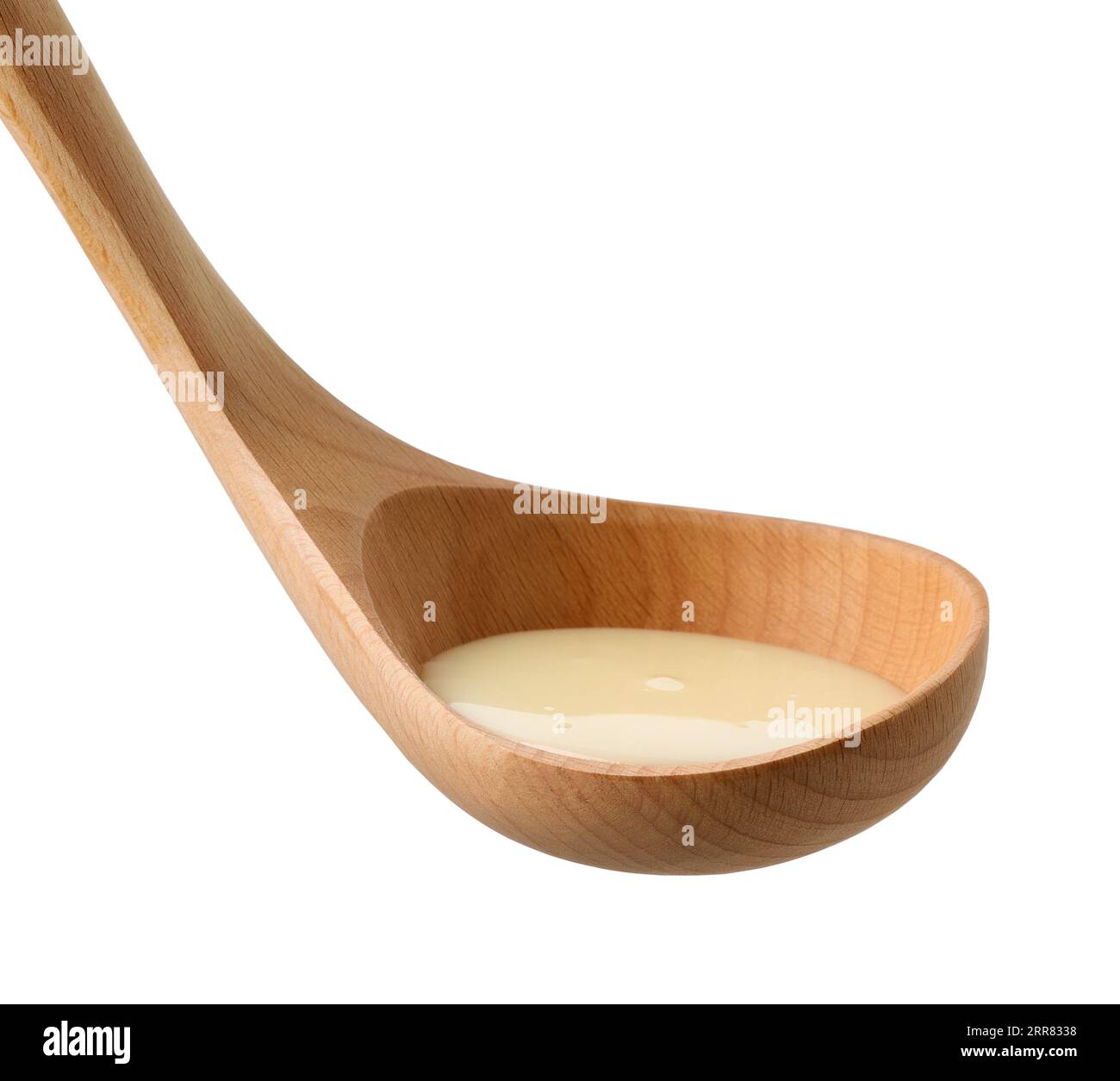 condensed milk in wooden ladle isolated on white background Stock Photo ...