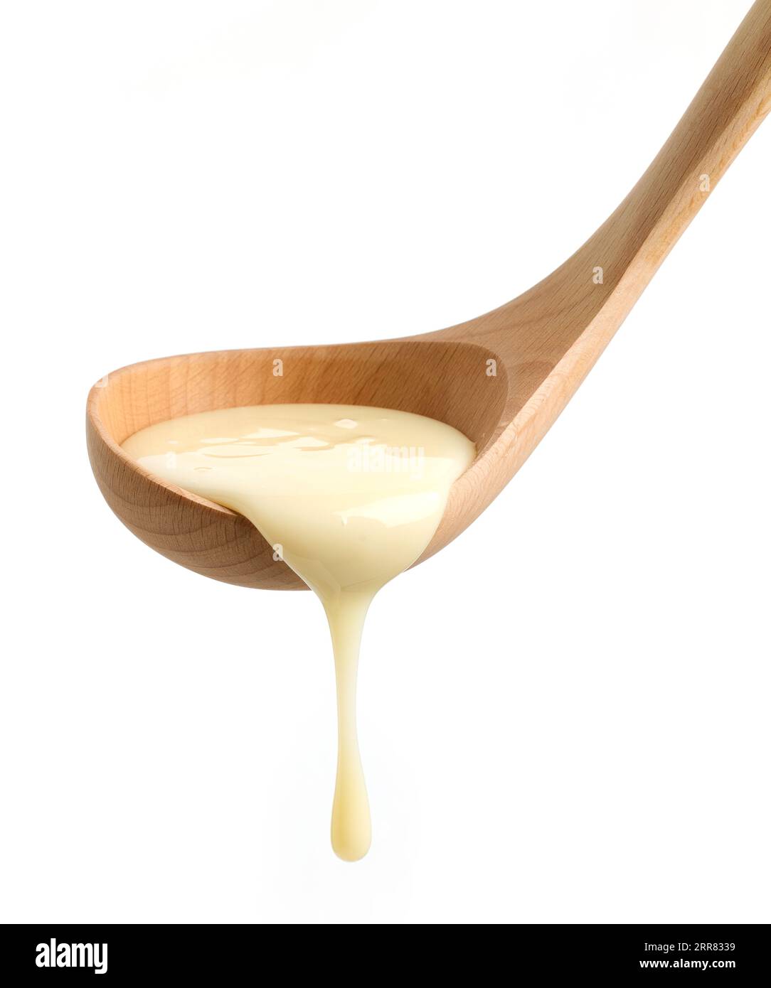 condensed milk in wooden ladle isolated on white background Stock Photo ...