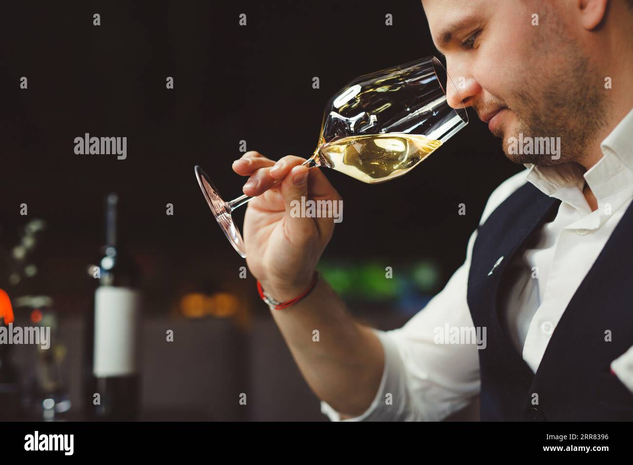 Wine expert smells alcoholic drink to give it rating Stock Photo - Alamy