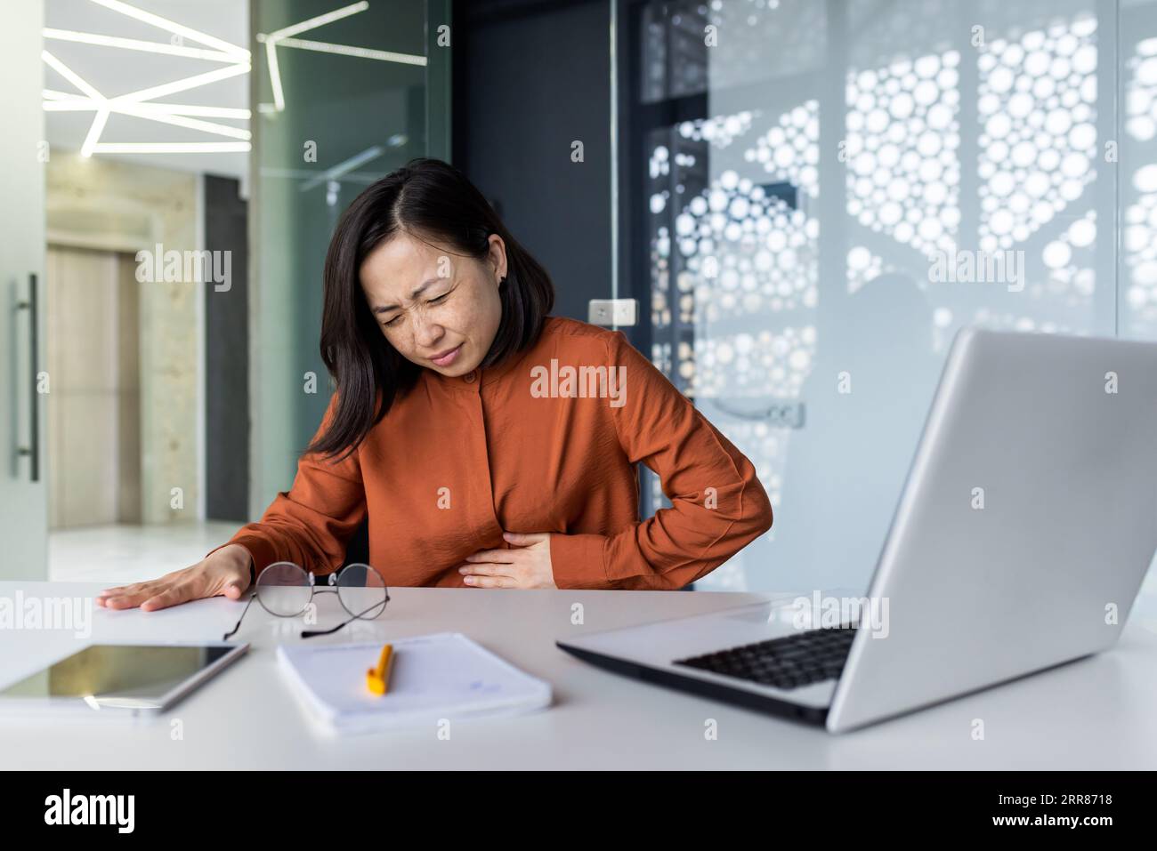 Sick woman at workplace has acute stomach pain, asian business woman ...