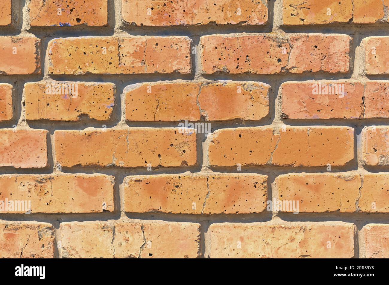 textured red brick wall. cracked old bricks on a bright sunny day Stock ...