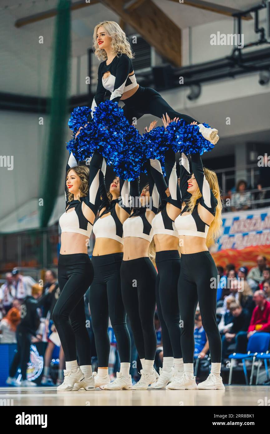 Cheerleader doing a split while other girls holding her up in the air ...