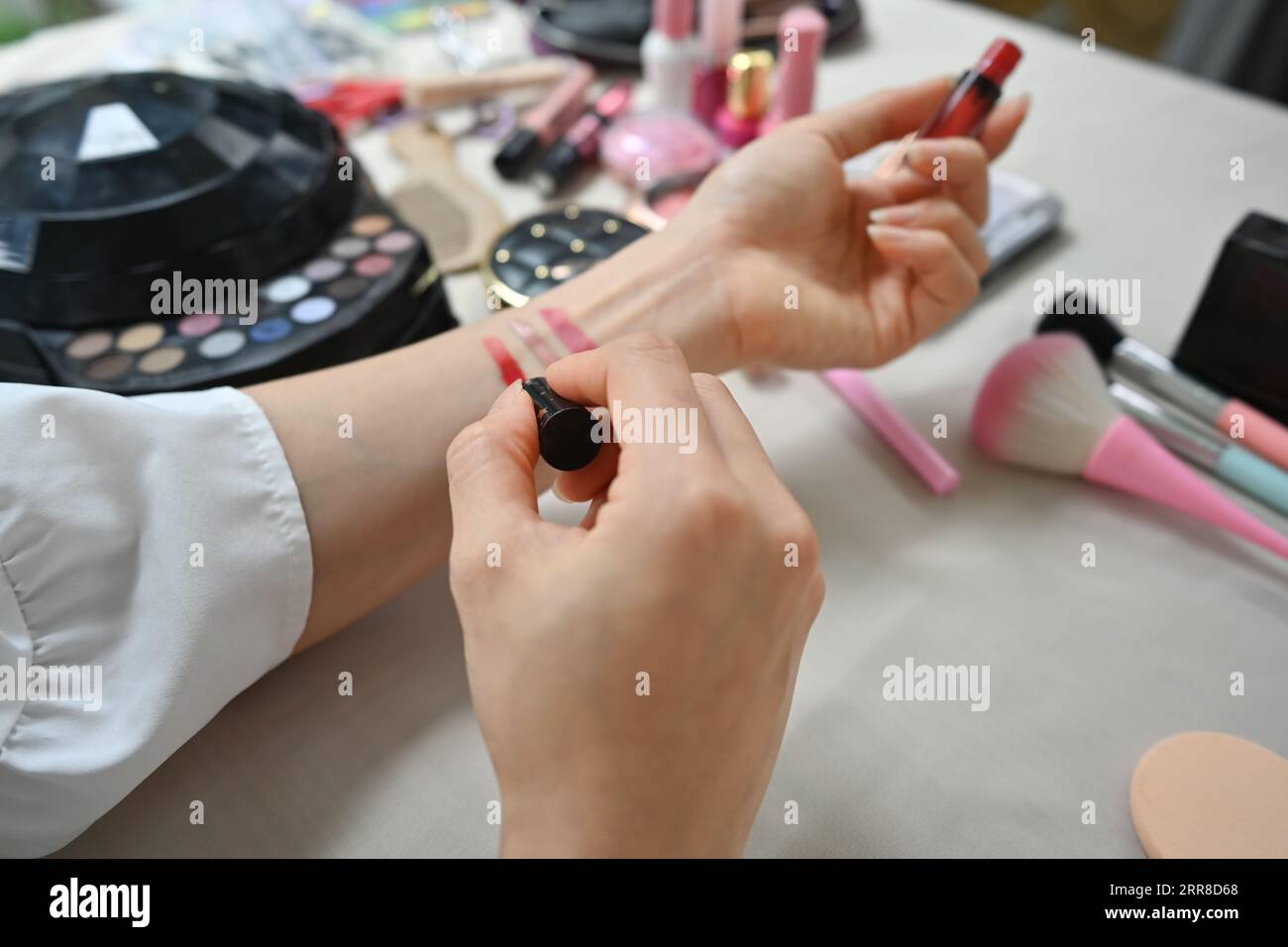 Closeup shot of female makeup artist testing new lipstick different ...