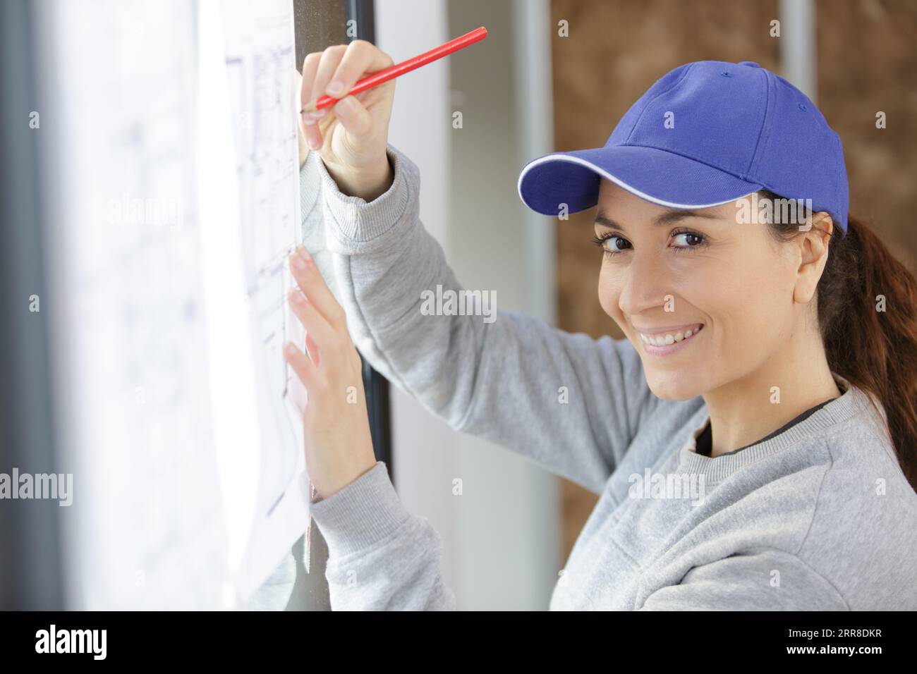 female architect drawing building plans with pencil Stock Photo - Alamy