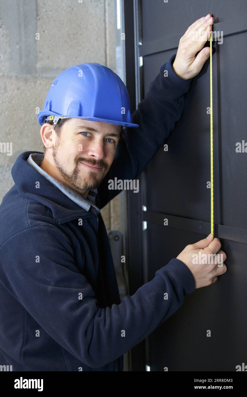 construction worker measuring door frame with measuring tape Stock ...