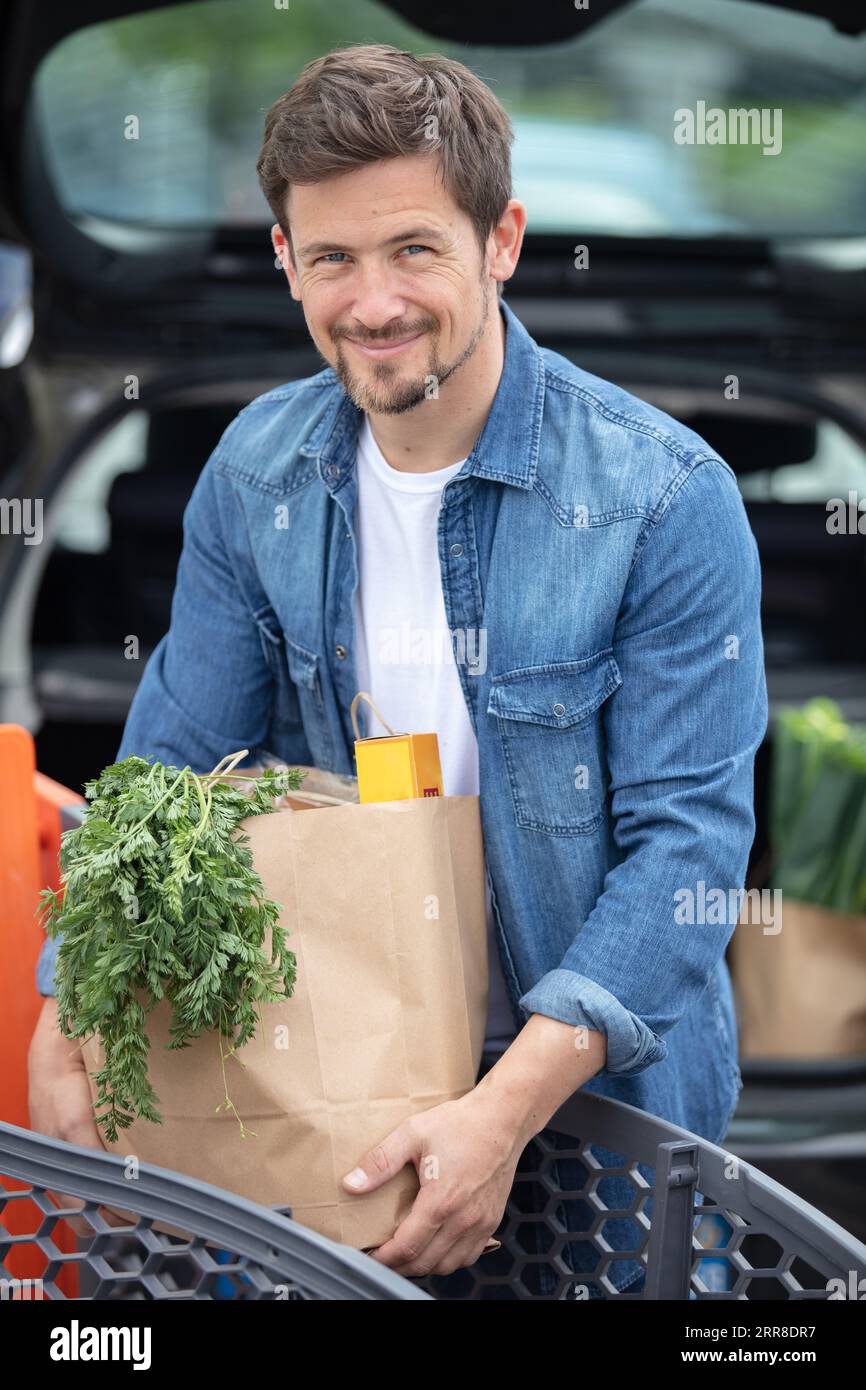 Man carrying many grocery bags hi-res stock photography and images - Alamy