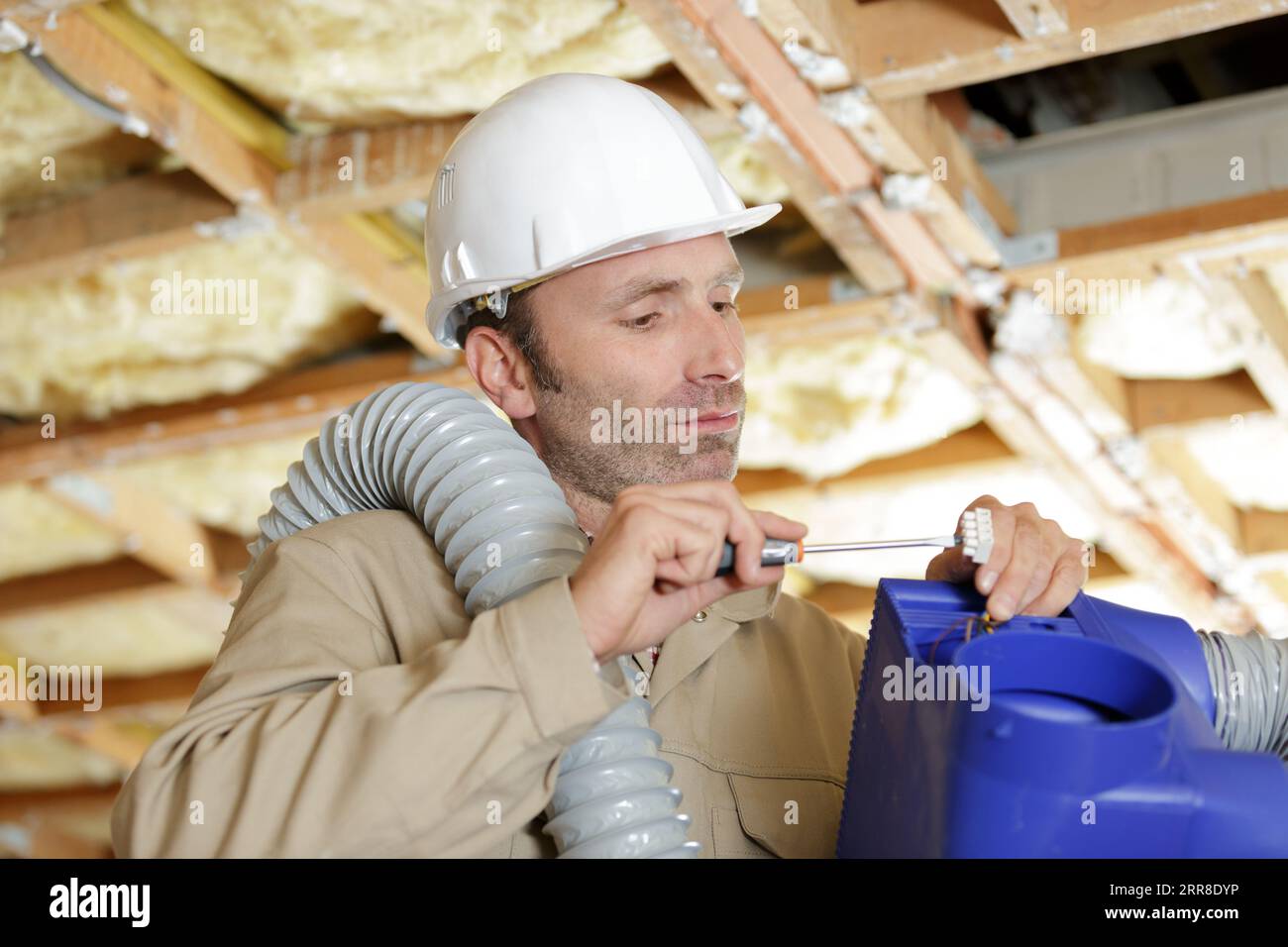 man installing ventilation system in property under renovation Stock ...