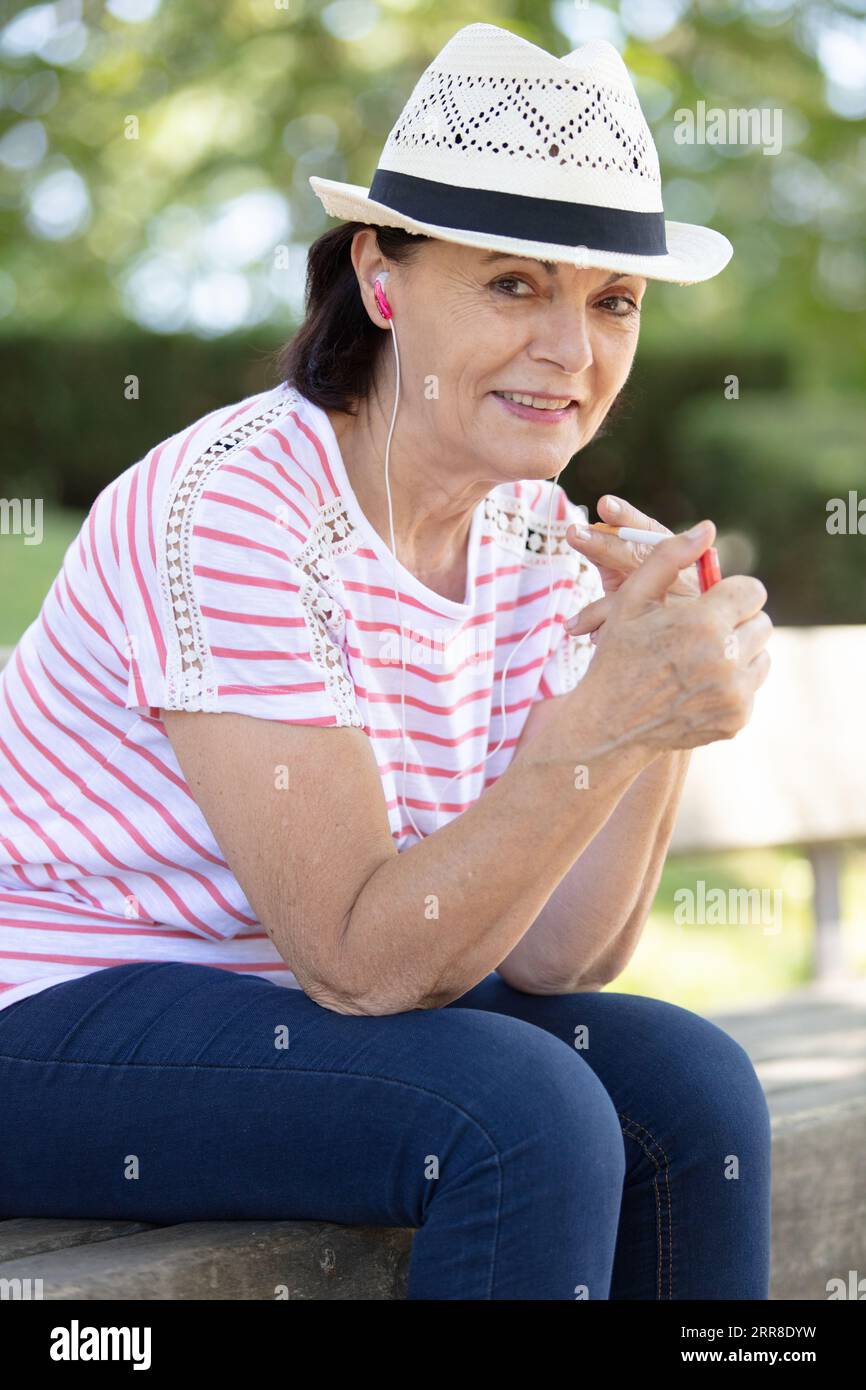 Elderly woman smoking cigarette outside hi-res stock photography and ...