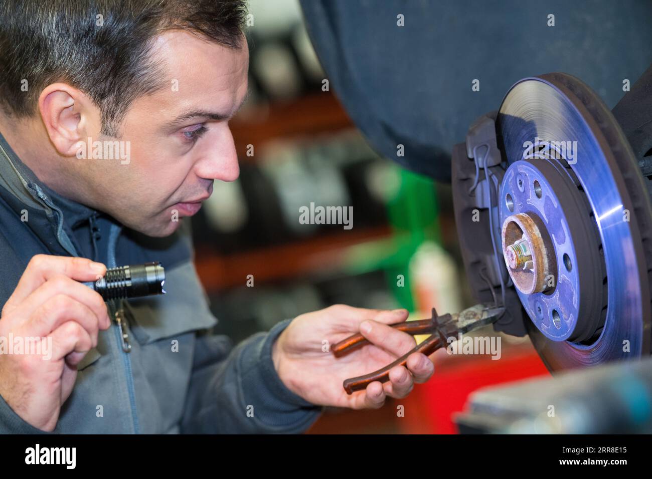 portrait of mechanic replacing a wheel Stock Photo - Alamy