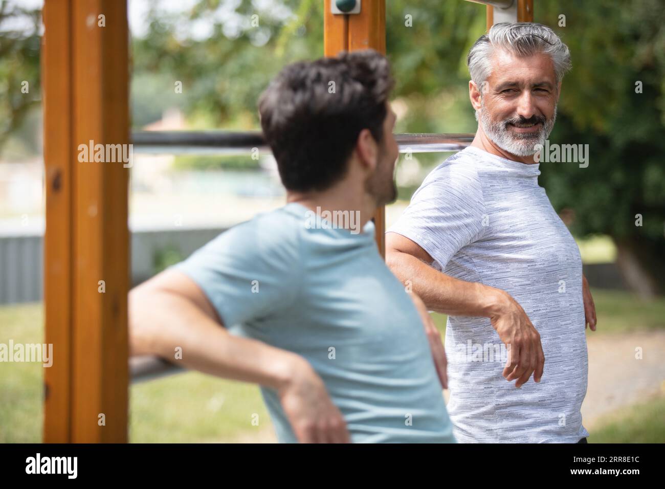 two concentrated sportsmen doing dips on horizontal parallel bars Stock ...