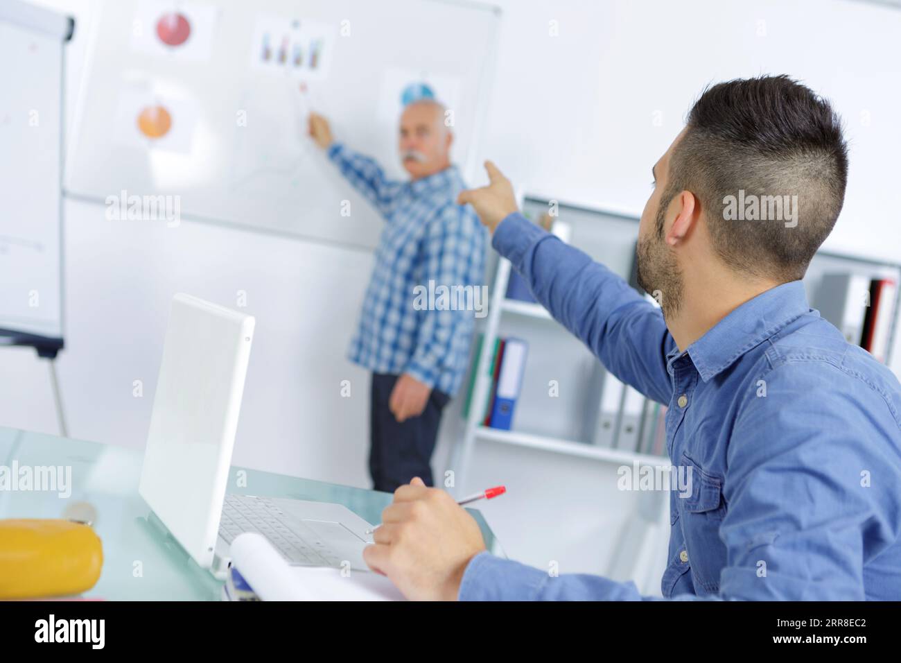 teacher and student pointing to a board Stock Photo - Alamy