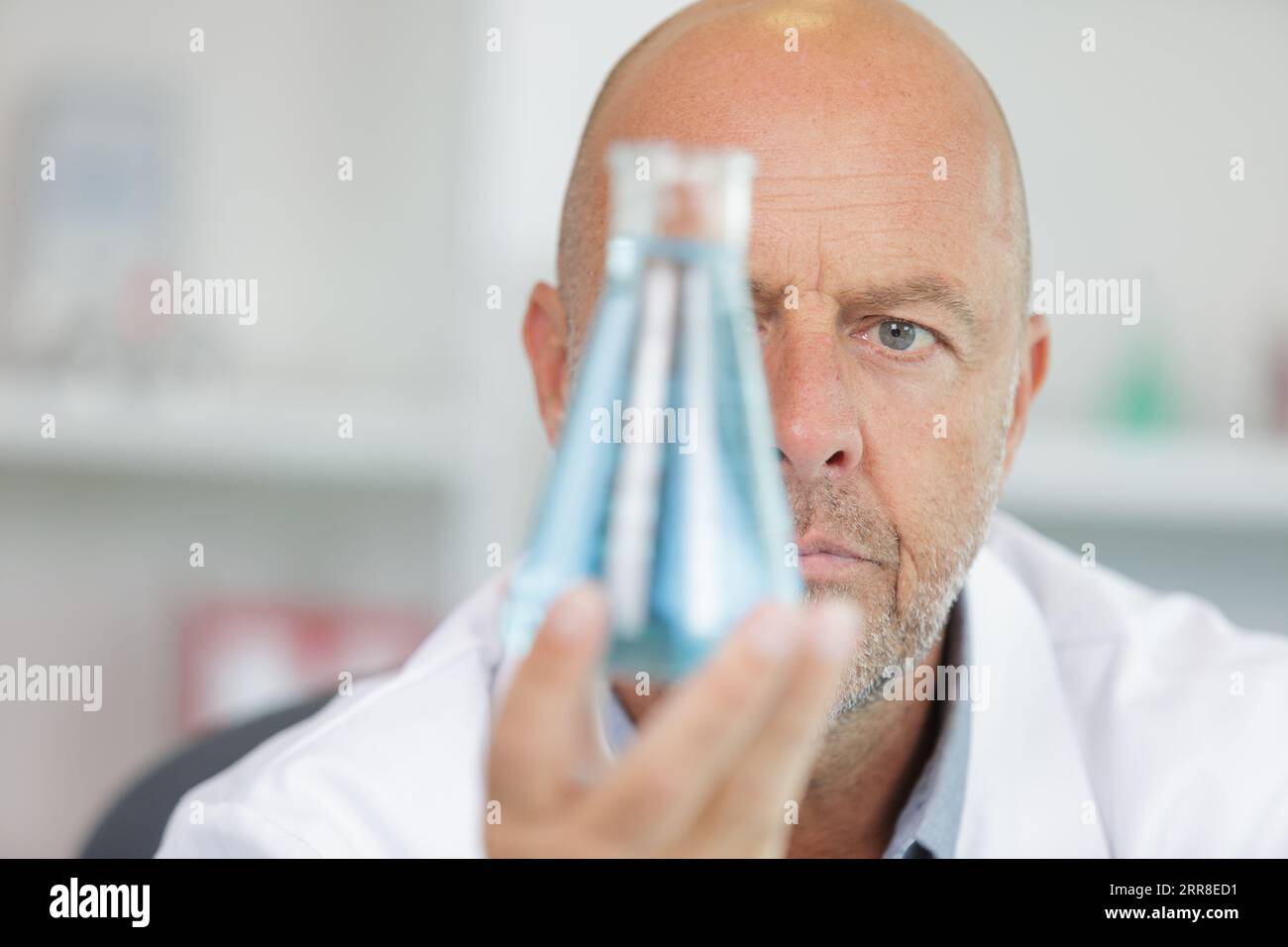 senior scientist holding flask in chemical lab Stock Photo - Alamy