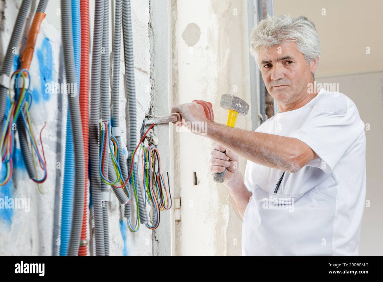 a builder is chiseling wall Stock Photo - Alamy