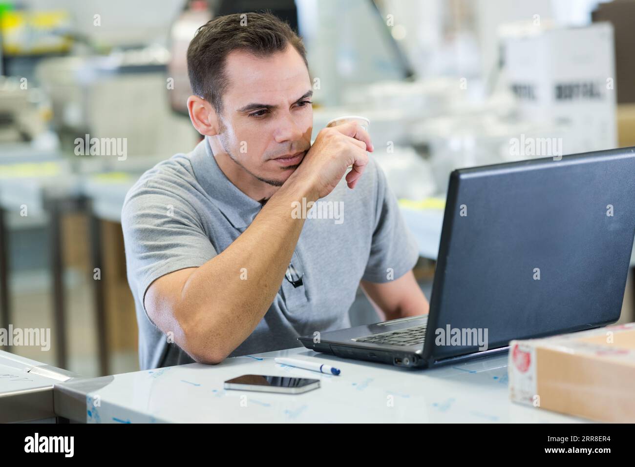 young man frowning to read his laptop screen Stock Photo - Alamy