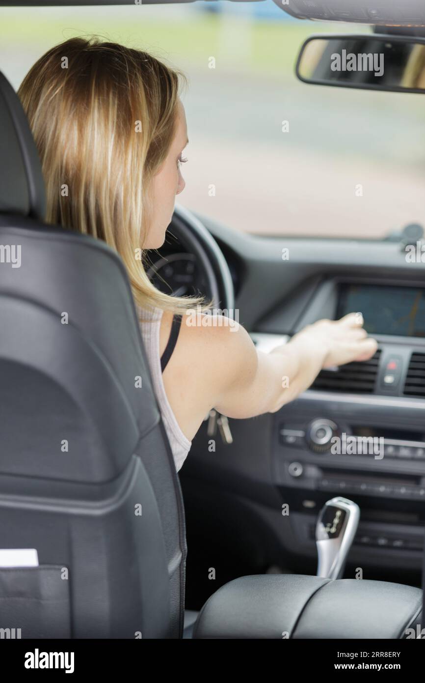 female driver turning on navigational system in car Stock Photo - Alamy