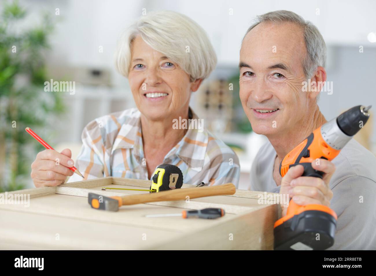 happy older couple holding diy tools Stock Photo - Alamy