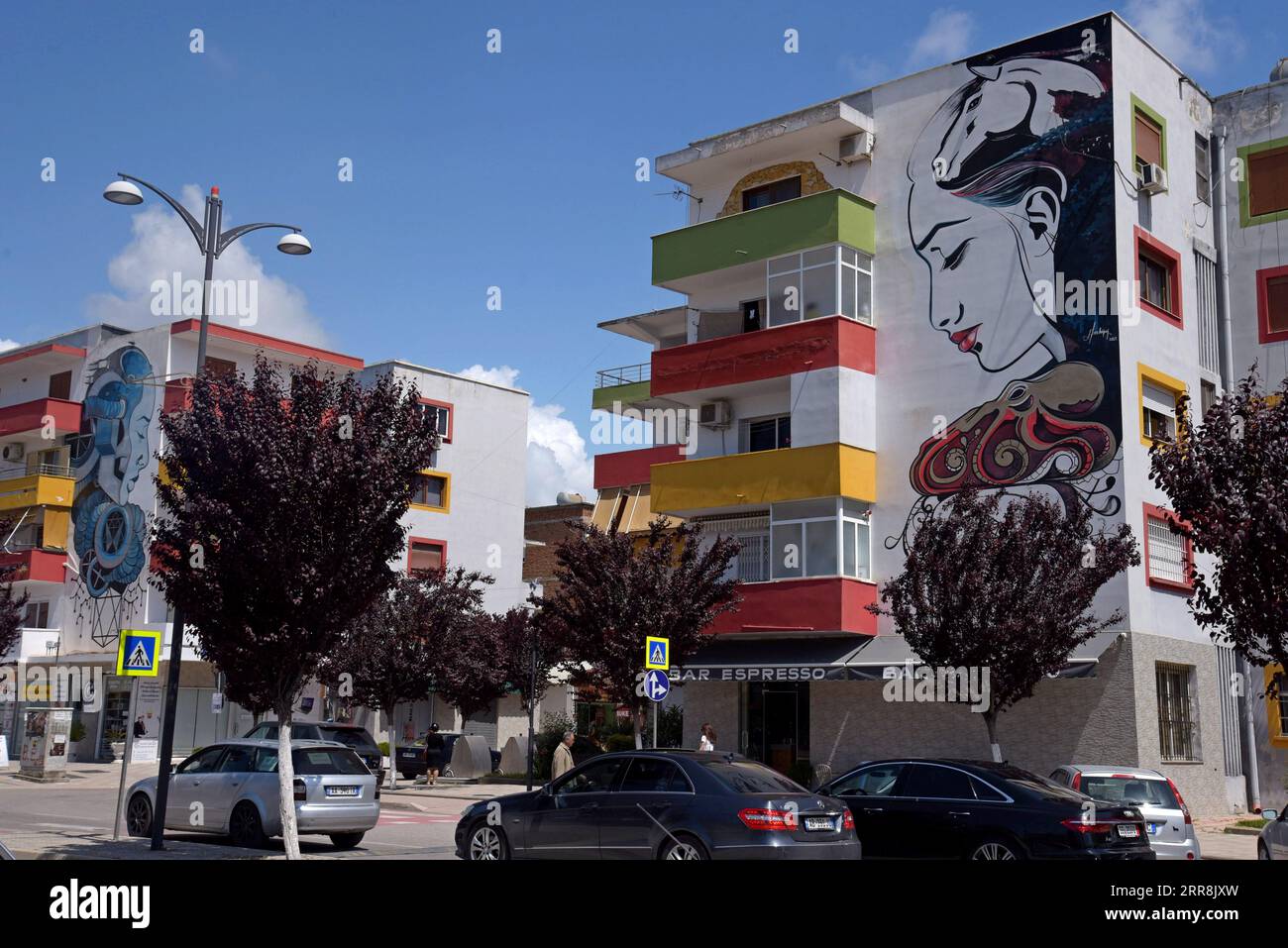 Colourful painted apartment blocks with street art murals in the town ...