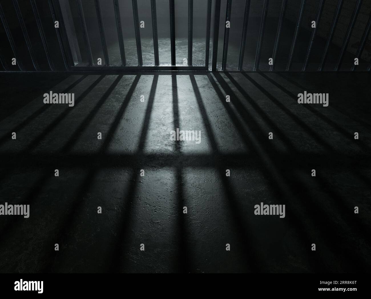 A closeup of a spolight behind jail cells iron bars casting shadows on the concrete prison floor ...