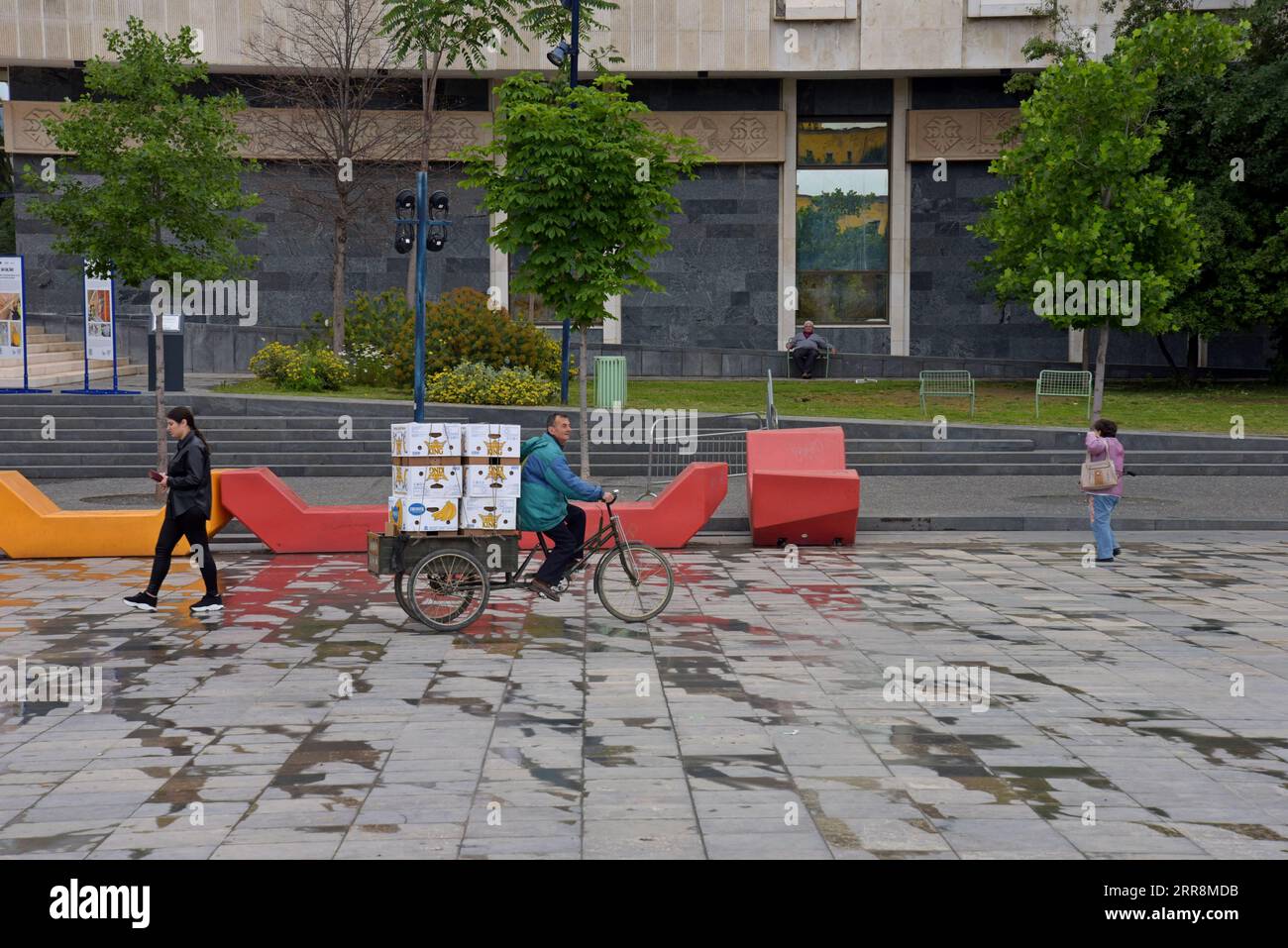 A man cycles past the National Historical Museum in Skanderbeg Square, using a cargo bike for ...