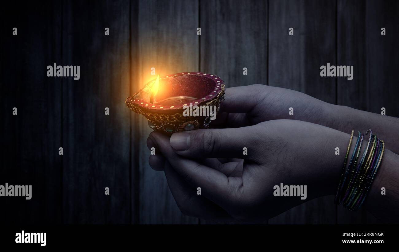 Woman hand holding Diya oil lamps for the Diwali festival. Diwali ...