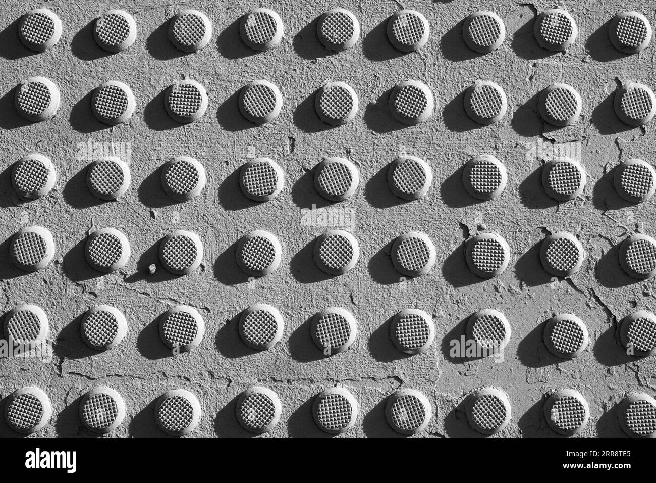 Textured iron rivets on a concrete surface. Black and white photo Stock ...
