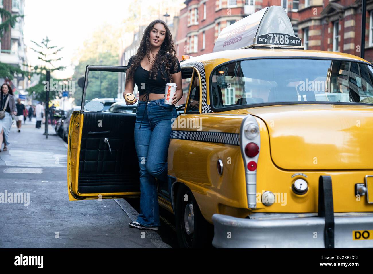 EDITORIAL USE ONLY Imogen French steps out of the DUNKIN' UK yellow cab ...