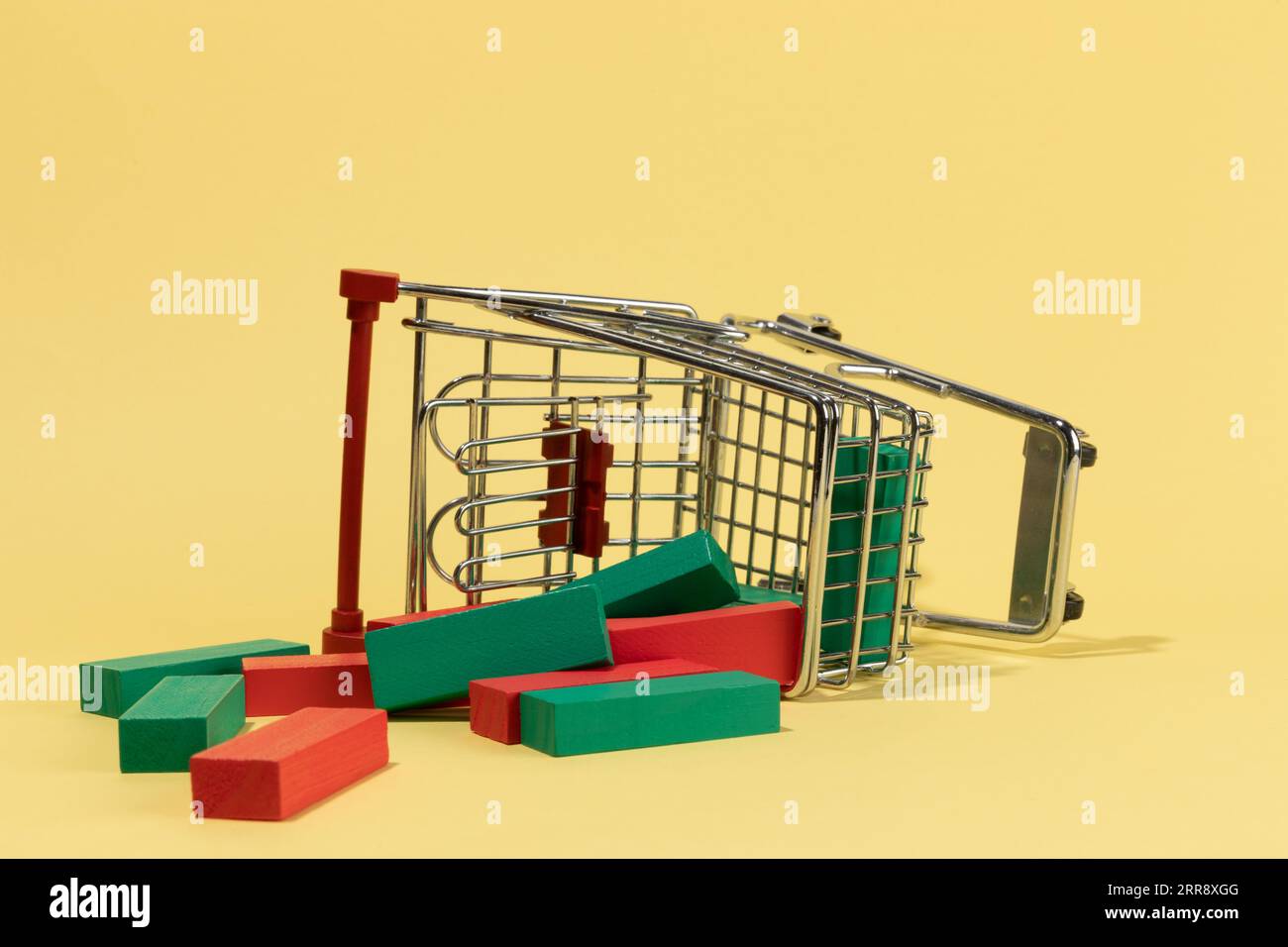 stock market candles falling from a shoping cart on a yellow background ...