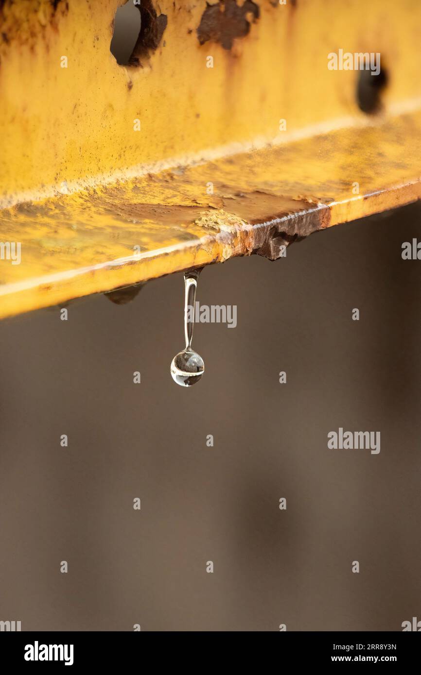 A drop of water that separates from a metal object Stock Photo - Alamy