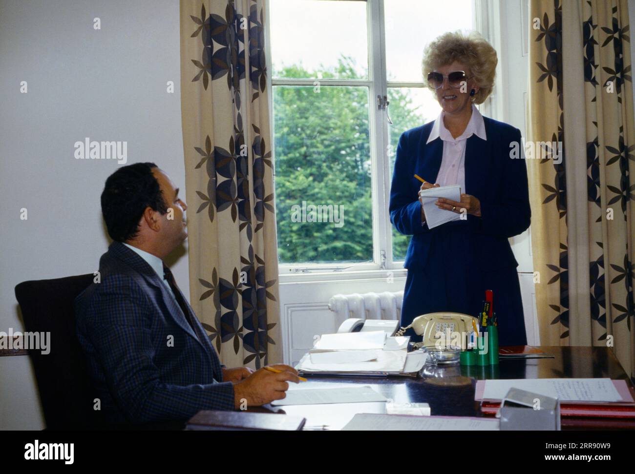 Secretary Taking Dictation From Boss In office 1980's Stock Photo - Alamy