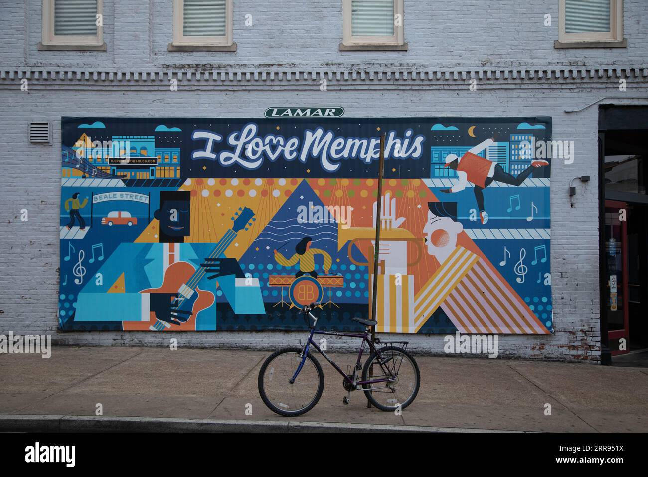 An urban brick wall with a vibrant street art mural painted on the side ...