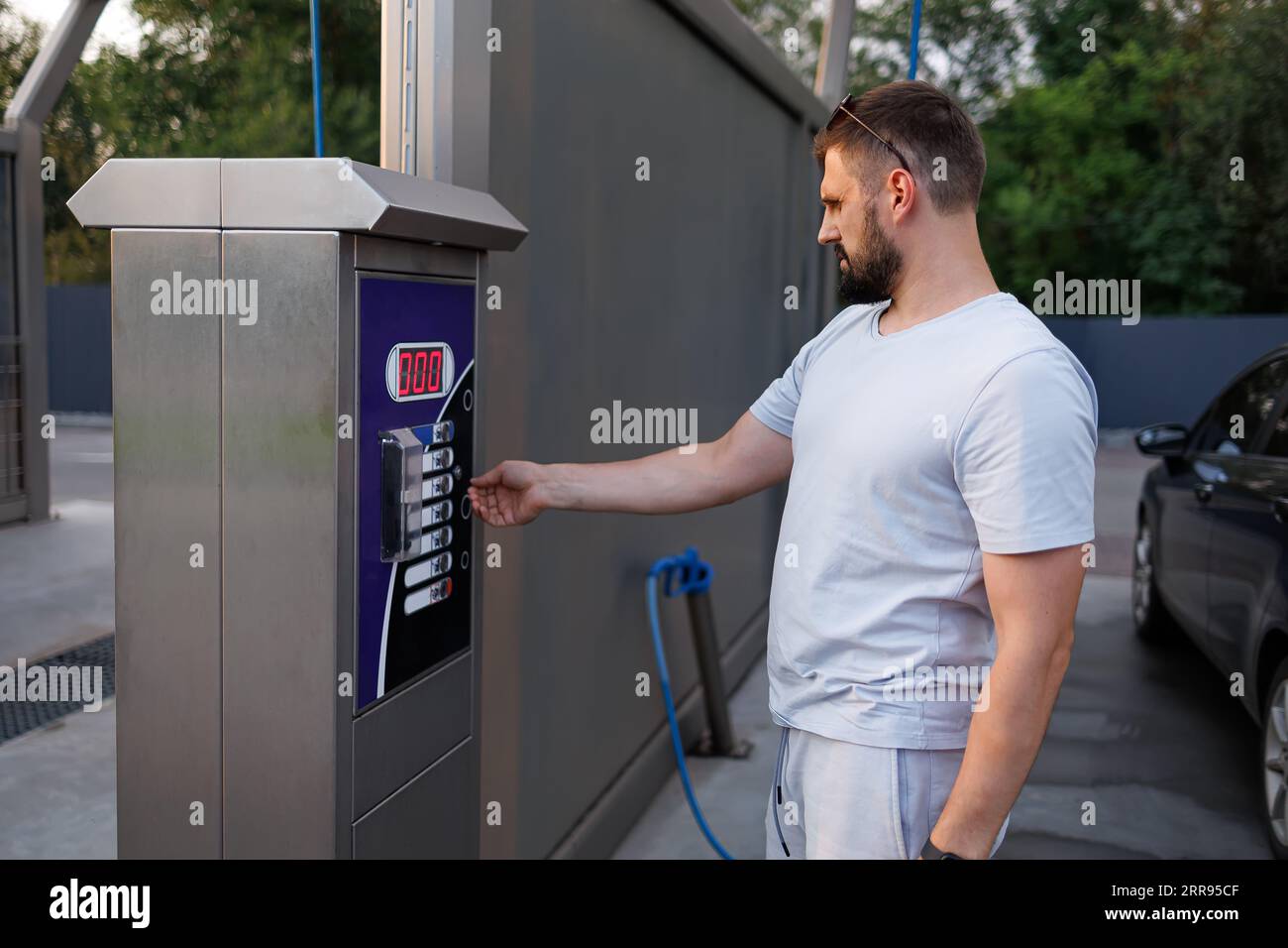After payment, the man selects the car wash mode. A car at a self ...