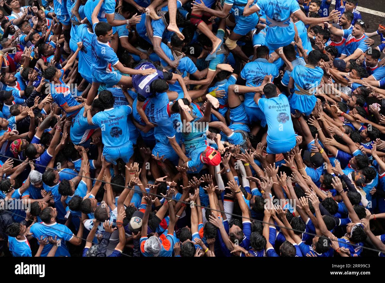 Revelers fall as they form human pyramids to reach an overhanging ...