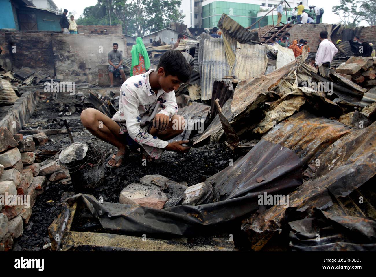 210607 -- DHAKA, June 7, 2021 -- A slum dweller searches for his ...