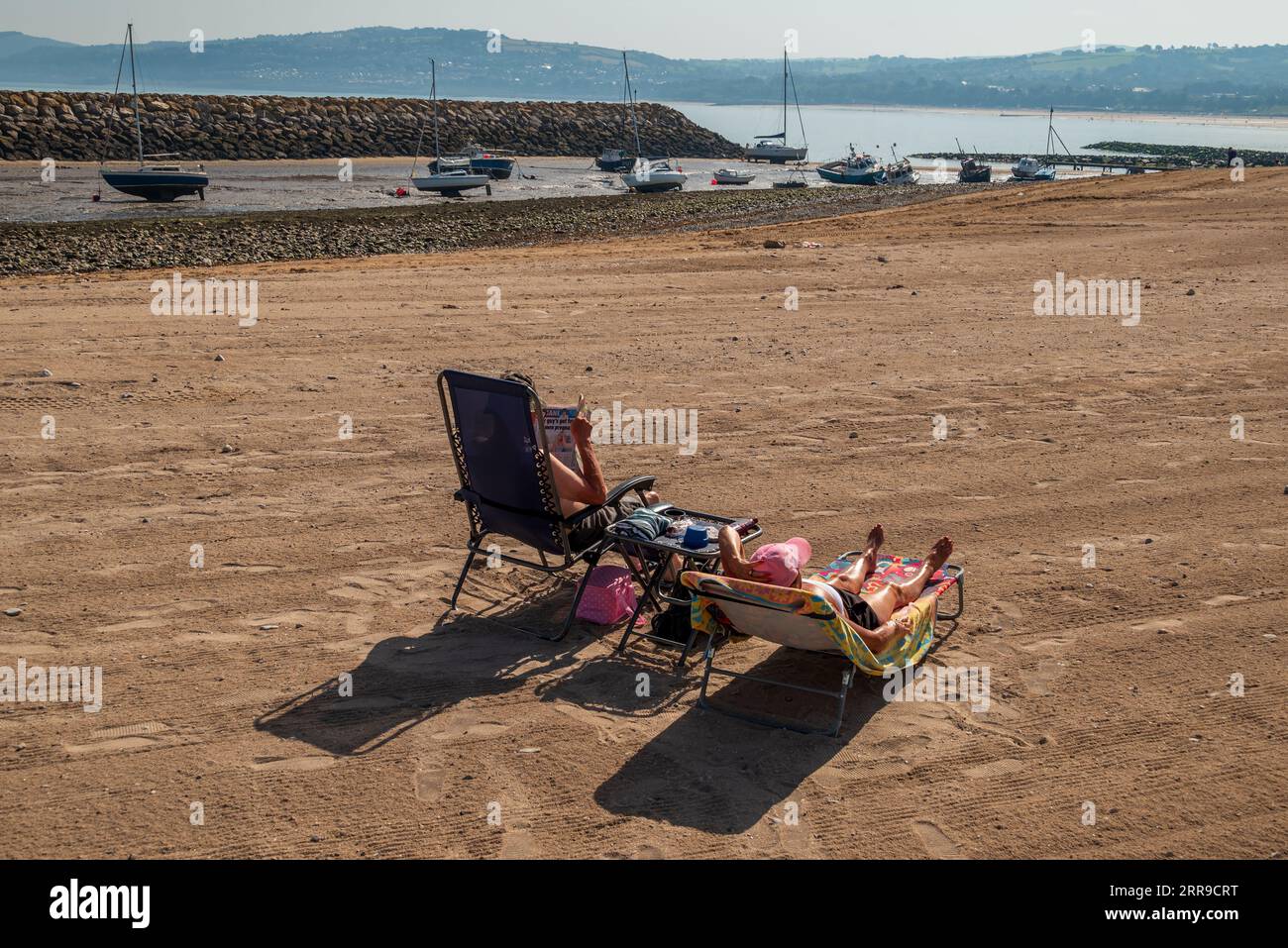 Sunbathers at Colwyn bay harbour in North Wales Stock Photo - Alamy