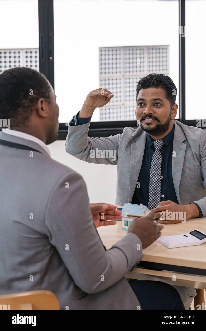 Indian businessman is having a discussion with an African American real ...