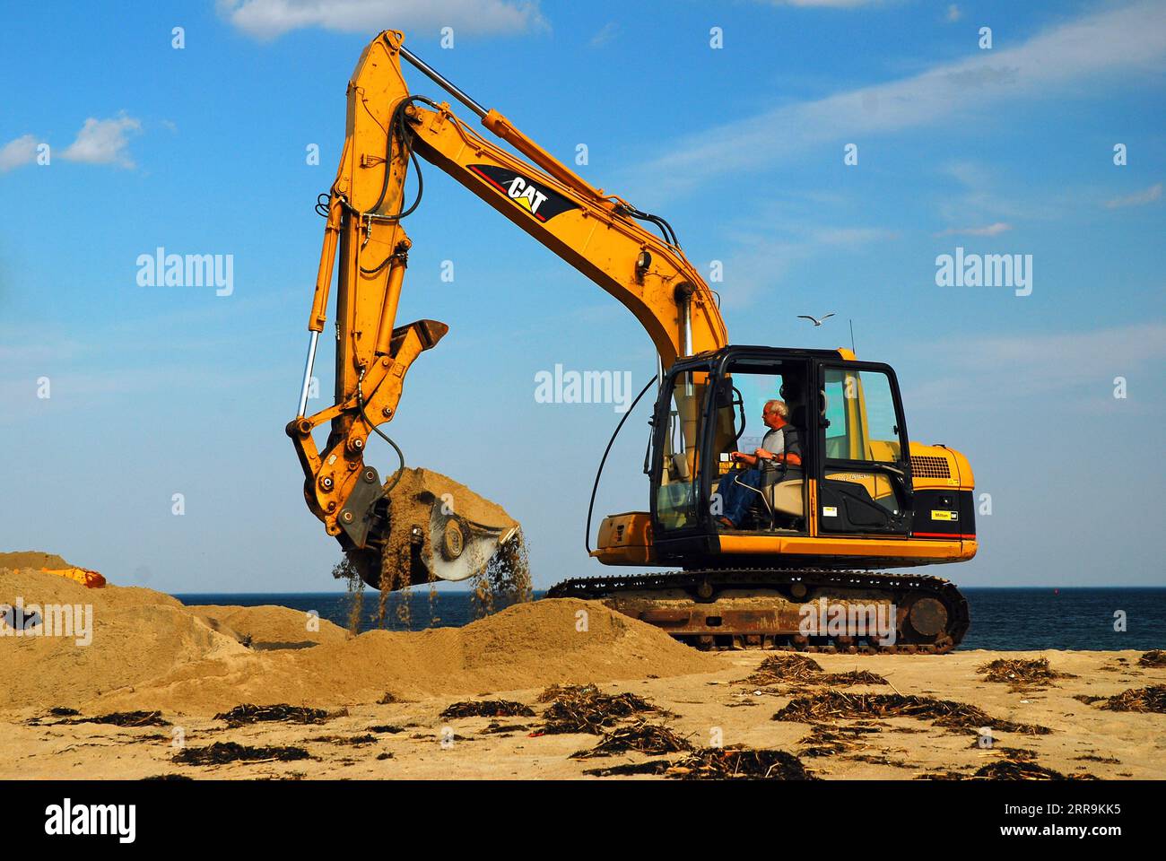 A worker replenishes the beach in Hampton, New Hampshire that was ...