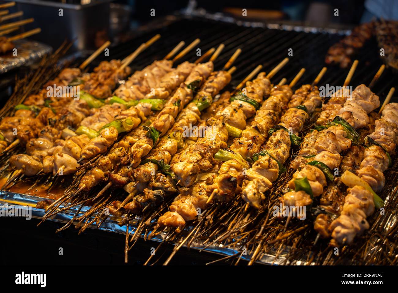 Grilling barbecue meat skewer kebab at traditional night market stall ...
