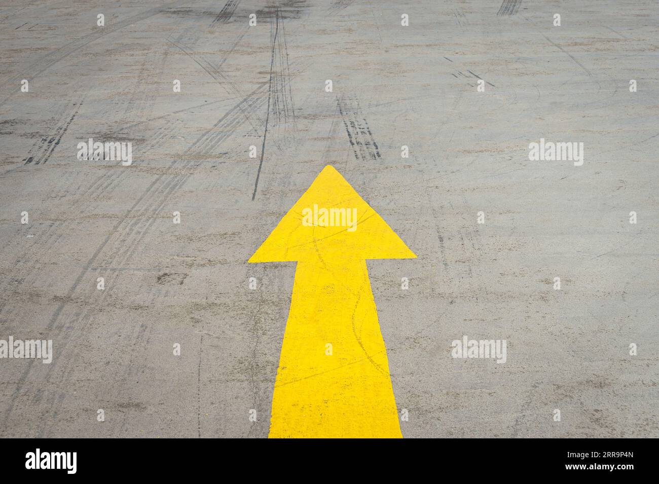 Yellow arrow painted on road surface, direction concept Stock Photo - Alamy