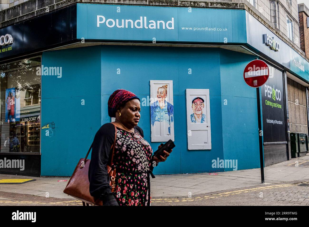 A woman walks past Poundland, a British variety store chain founded in ...