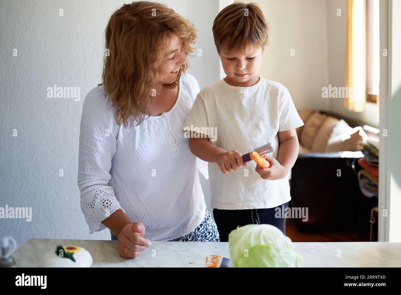 Mother teaches her son how to cook Stock Photo - Alamy