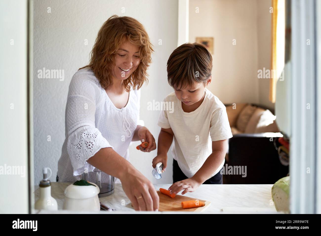 Mother teaches her son how to cook Stock Photo - Alamy