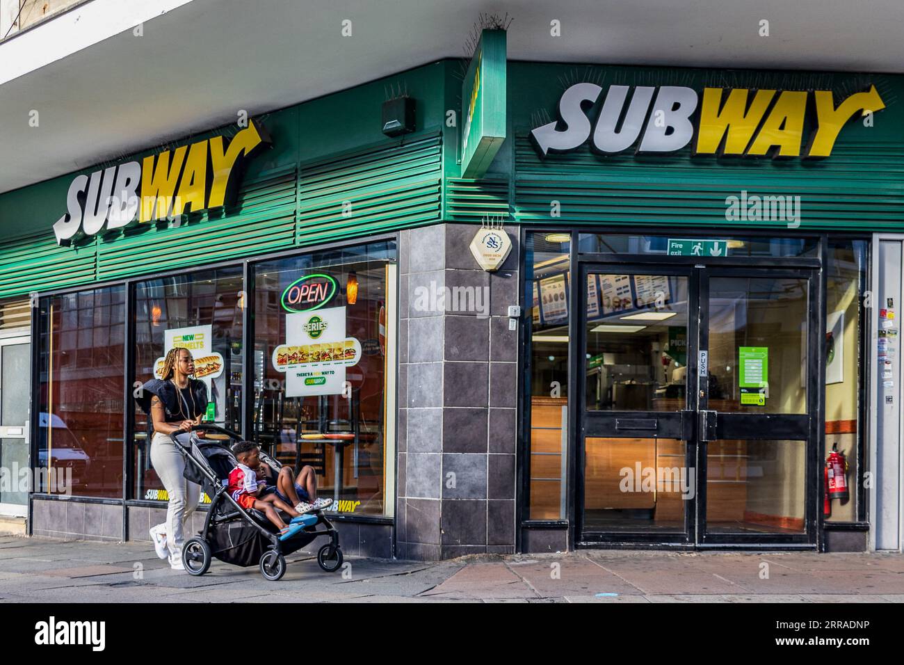 People walk past Subway, Subway IP LLC, an American multinational fast ...