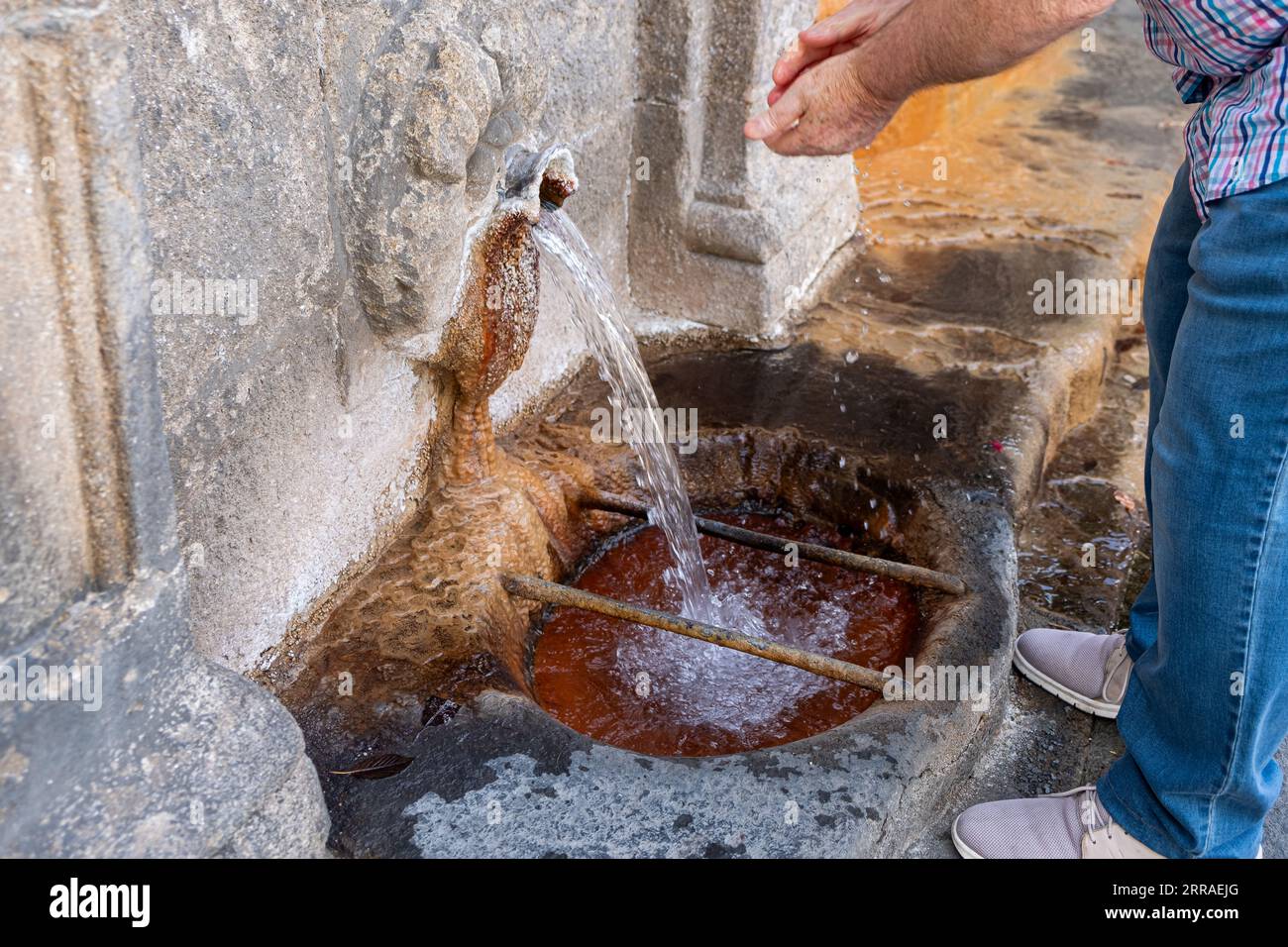 Man washing his hands in the hot springs of Ourense, known as Burgas ...