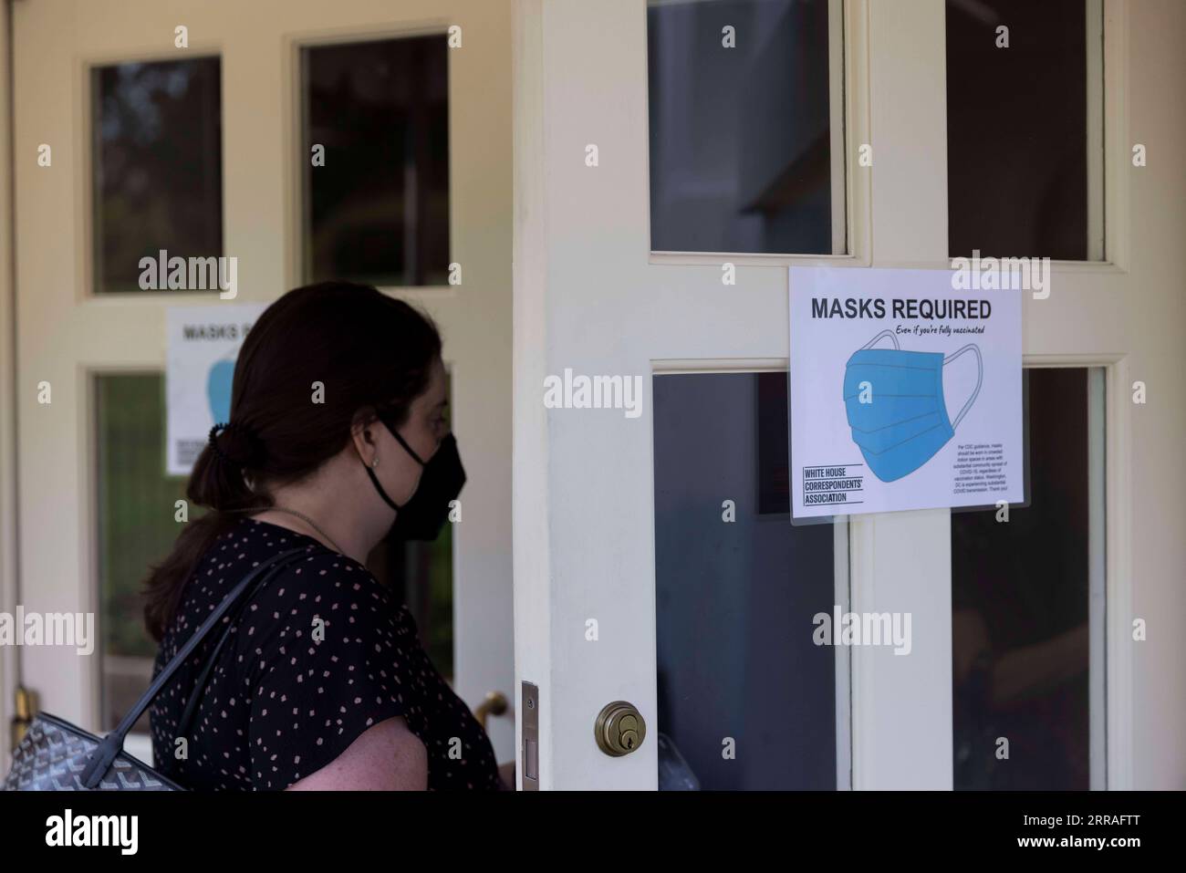 210729 -- WASHINGTON, July 29, 2021 -- A sign reading Masks Required is ...