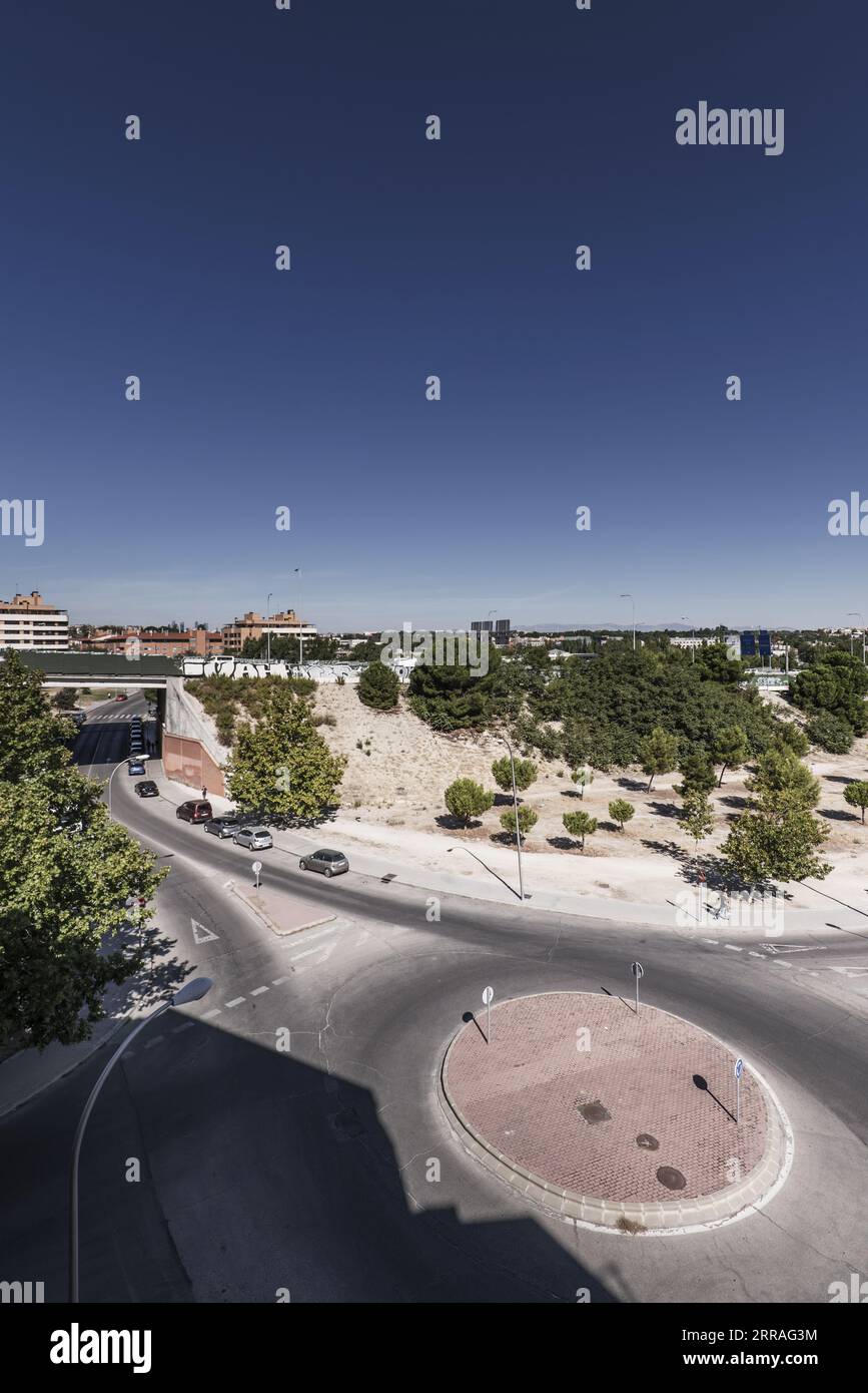 Views of a traffic roundabout on a street next to an overpass under a ...