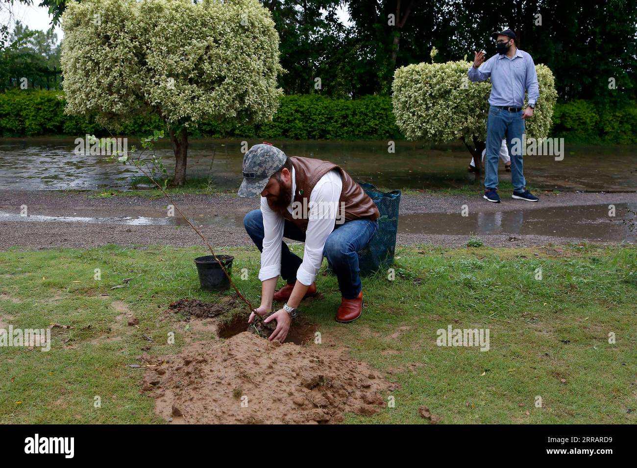 210814 -- ISLAMABAD, Aug. 14, 2021 -- A man plants a tree during a tree ...