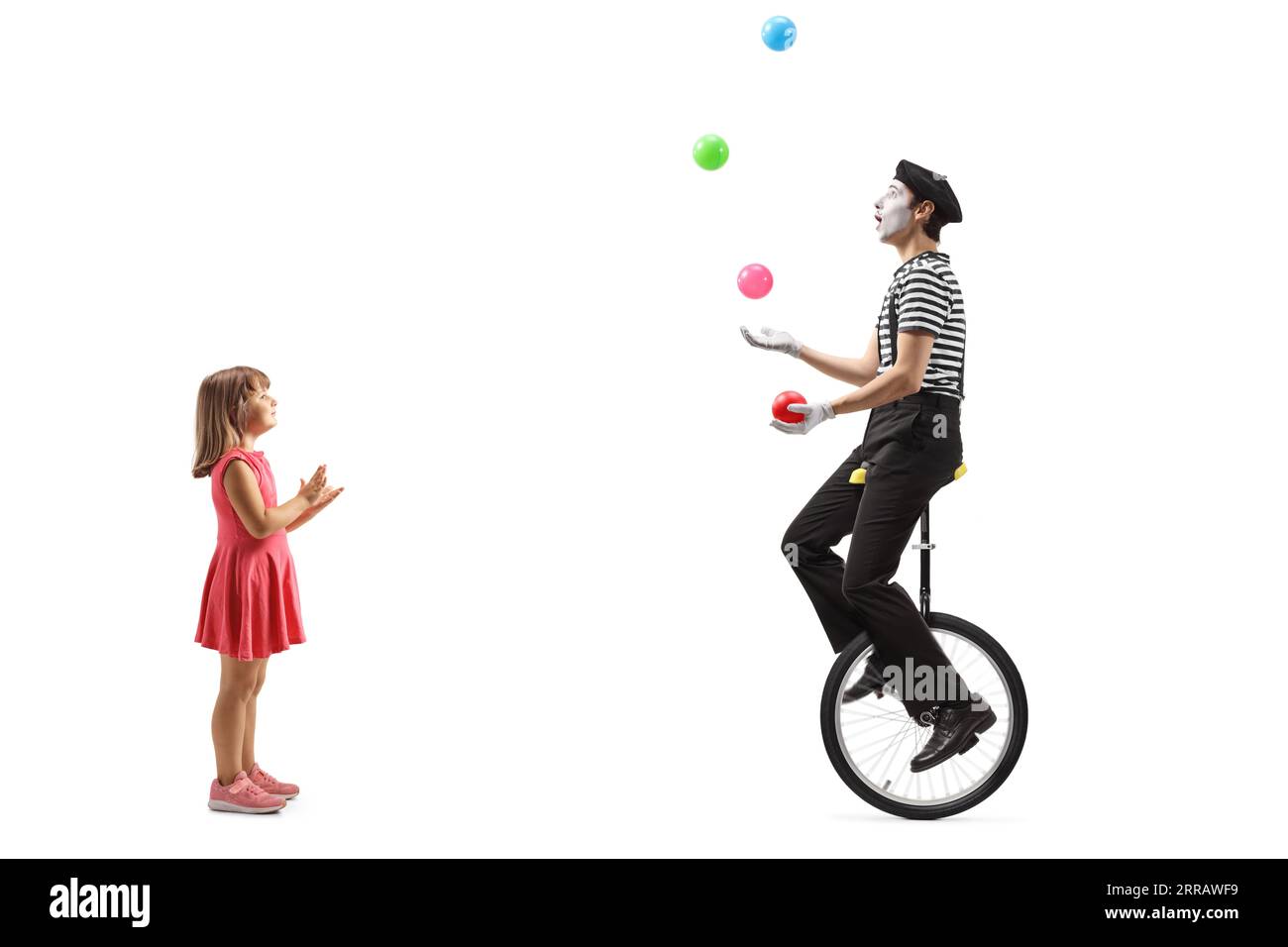 Little girl giving an applause and watching a mime juggling on a unicycle isolated on white ...