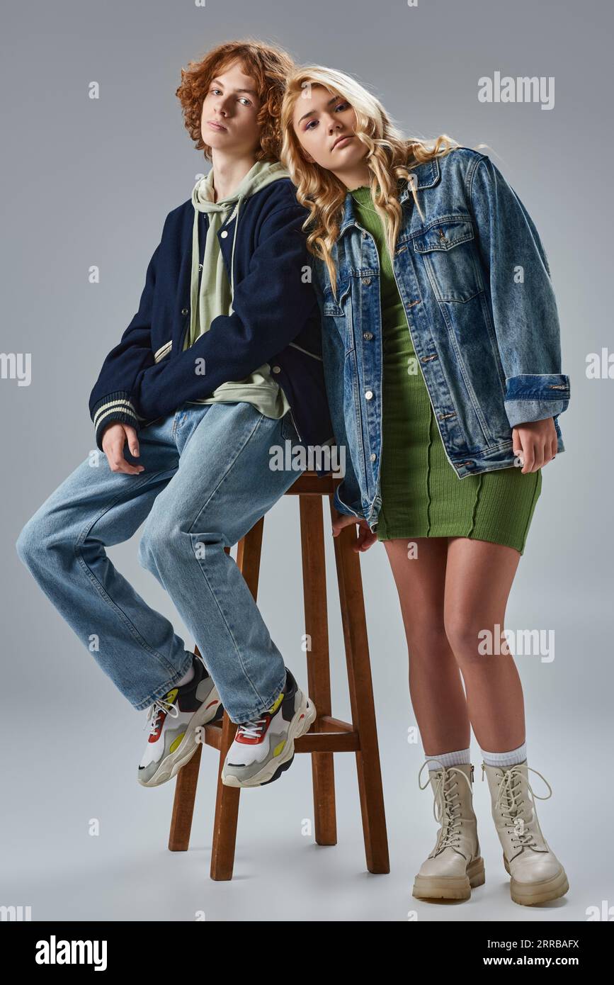 blonde teenage girl leaning on redhead boyfriend sitting on high stool ...