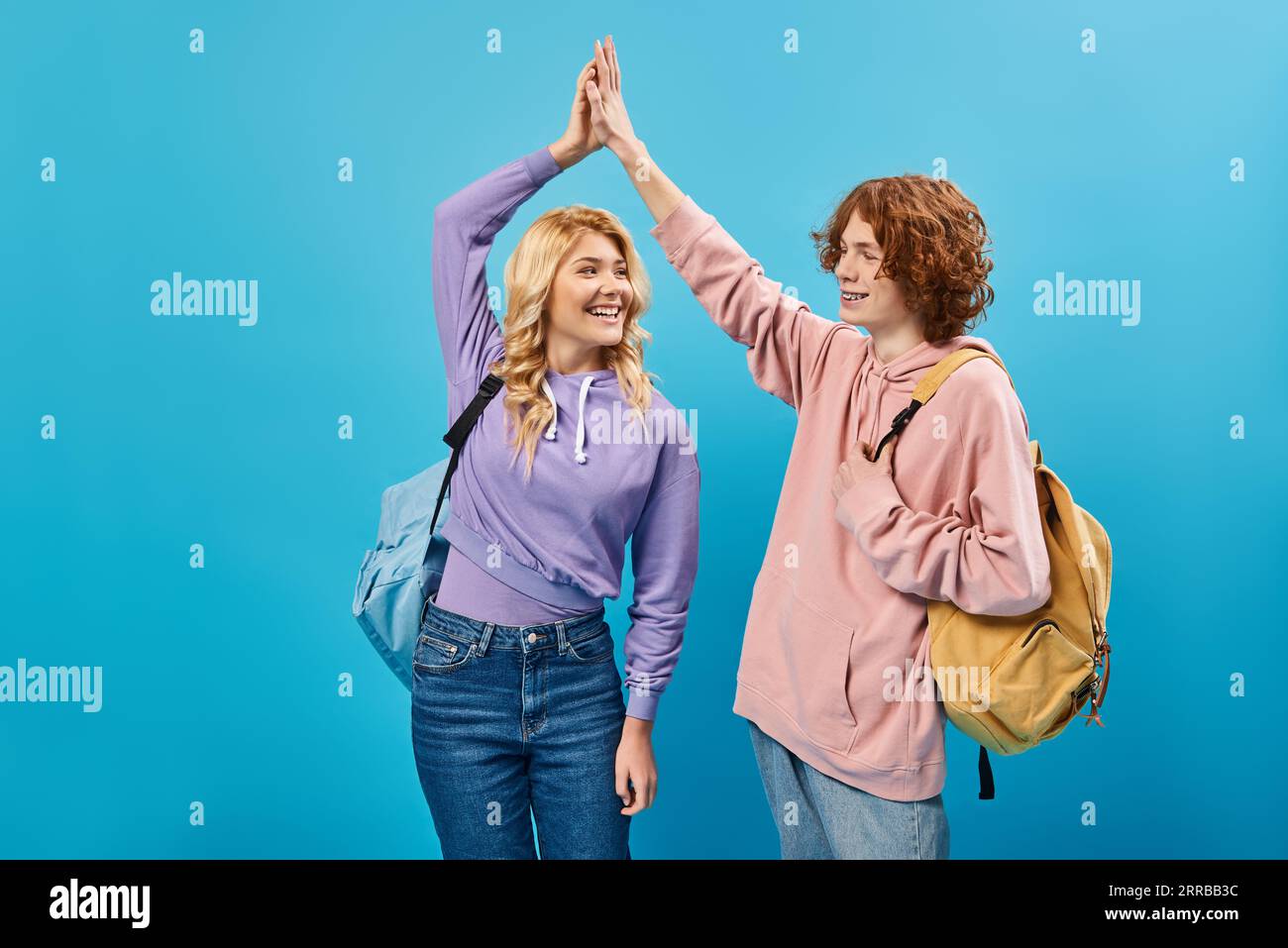 happy teenage classmates with backpacks wearing trendy clothes and ...